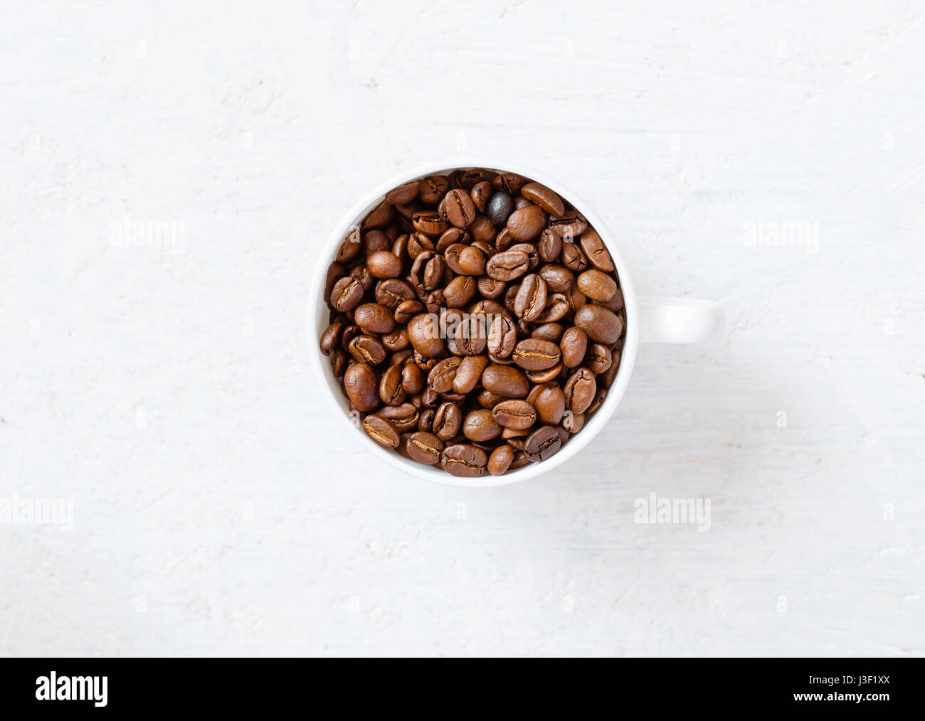Coffee cup full of coffee beans on white wooden background Stock Photo ...