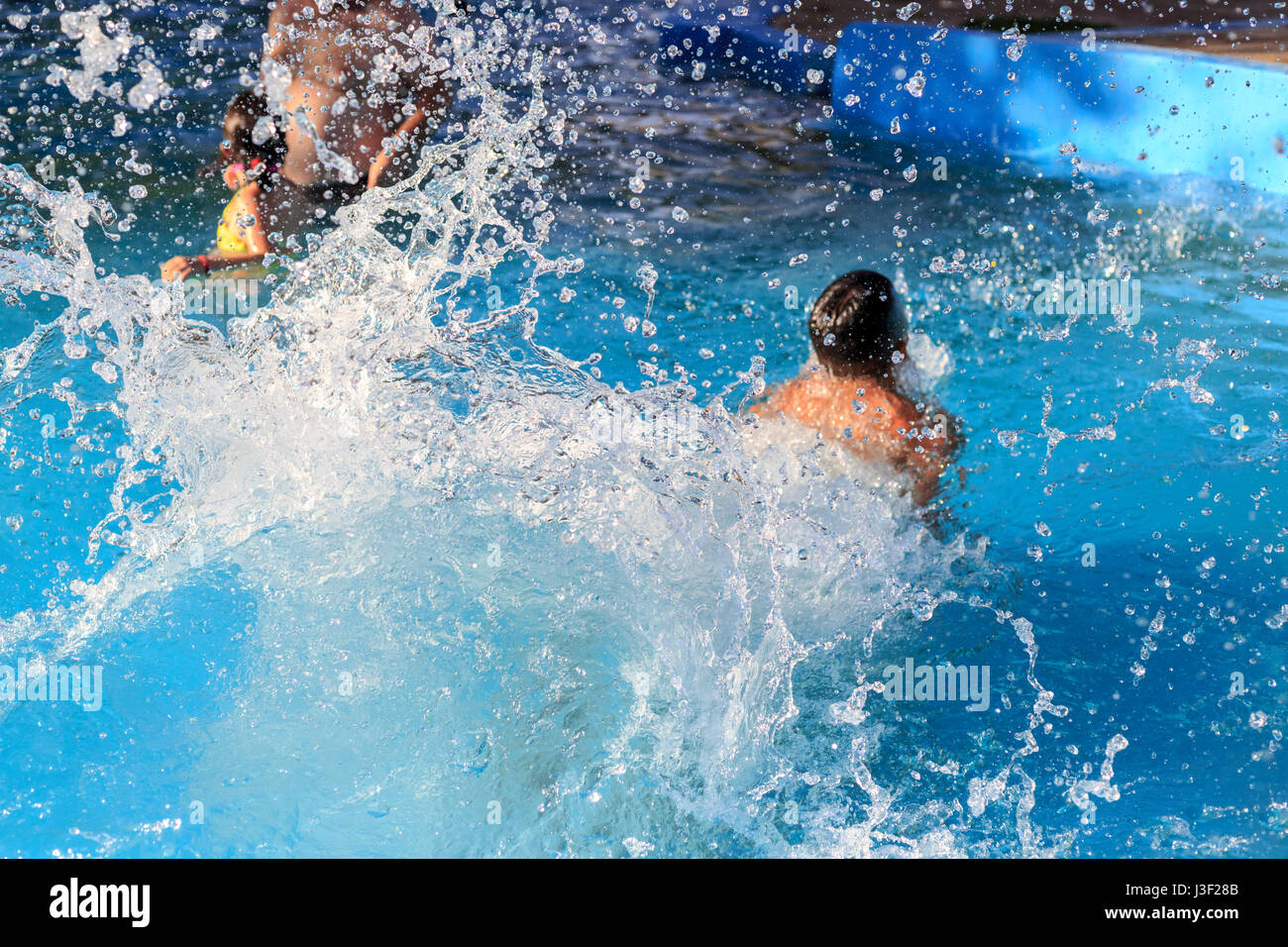 Children playing at swimming pool. Water splash Stock Photo - Alamy
