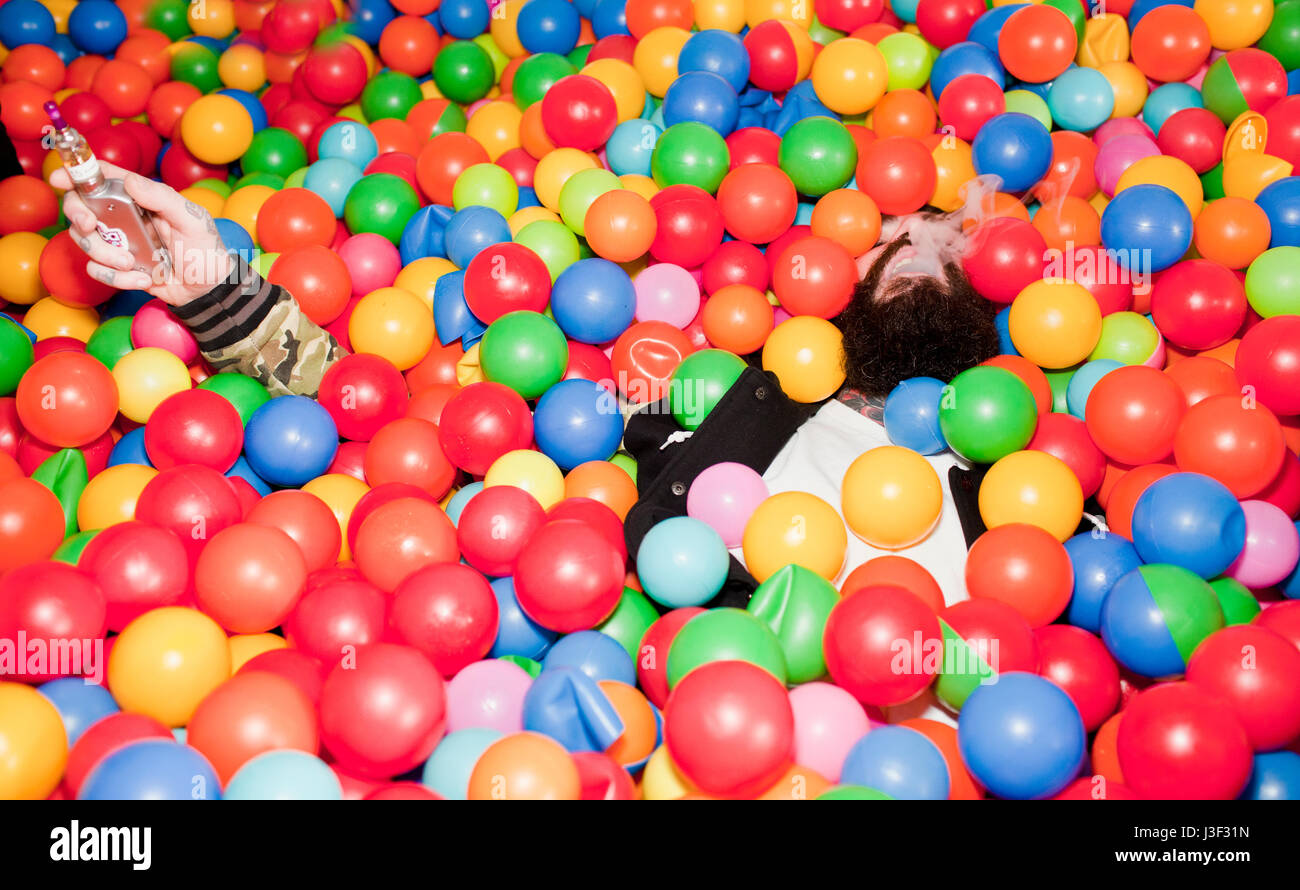 Young man playing in a ball pit Stock Photo - Alamy