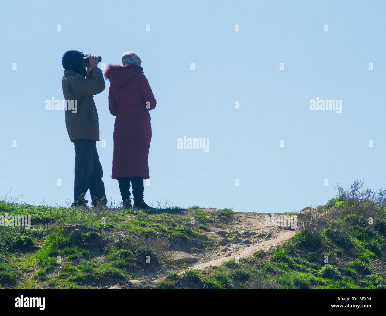 Two people look through the binoculars on mountain Stock Photo - Alamy