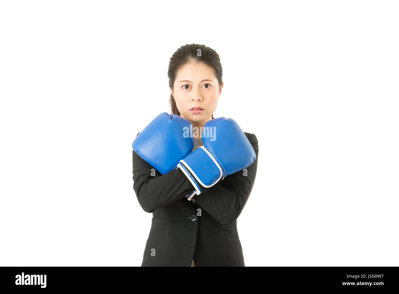 Business woman in boxing gloves cross arms defense from attack standing ...