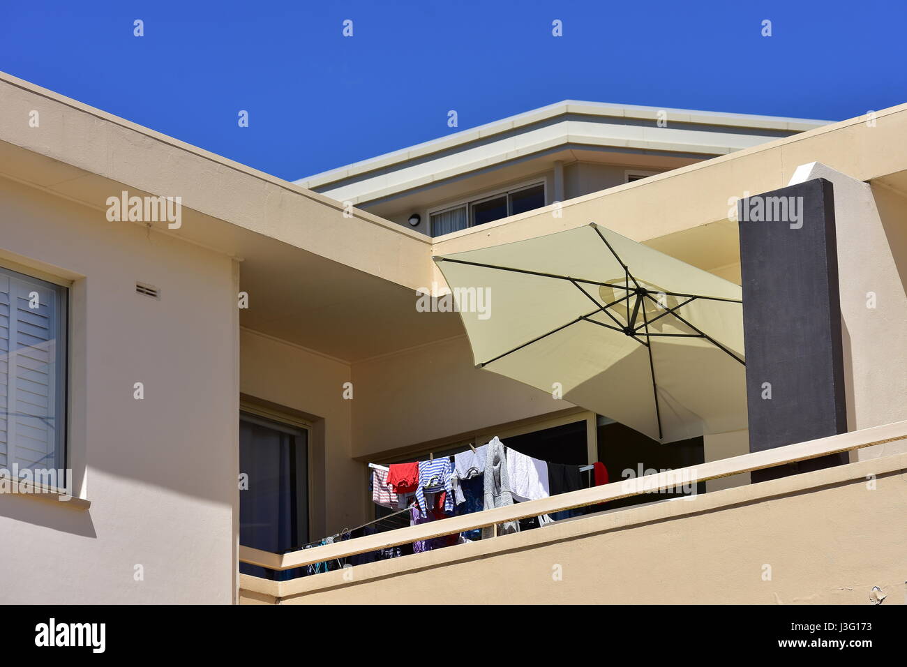 Drying laundry on balcony of apartment building with plaster cladding ...