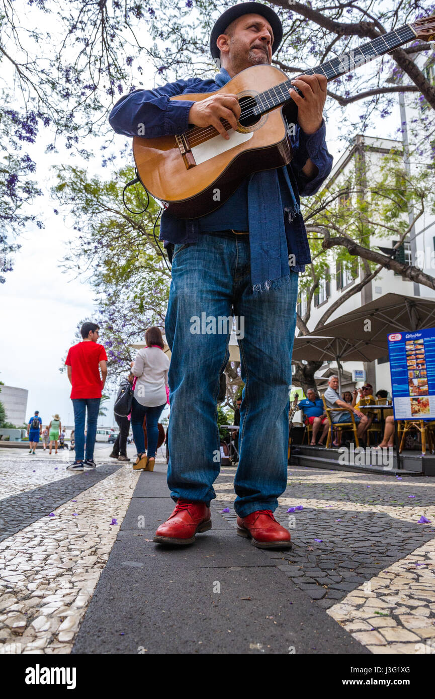 Street entertainer or busker playing a Spanish guitar on the city ...