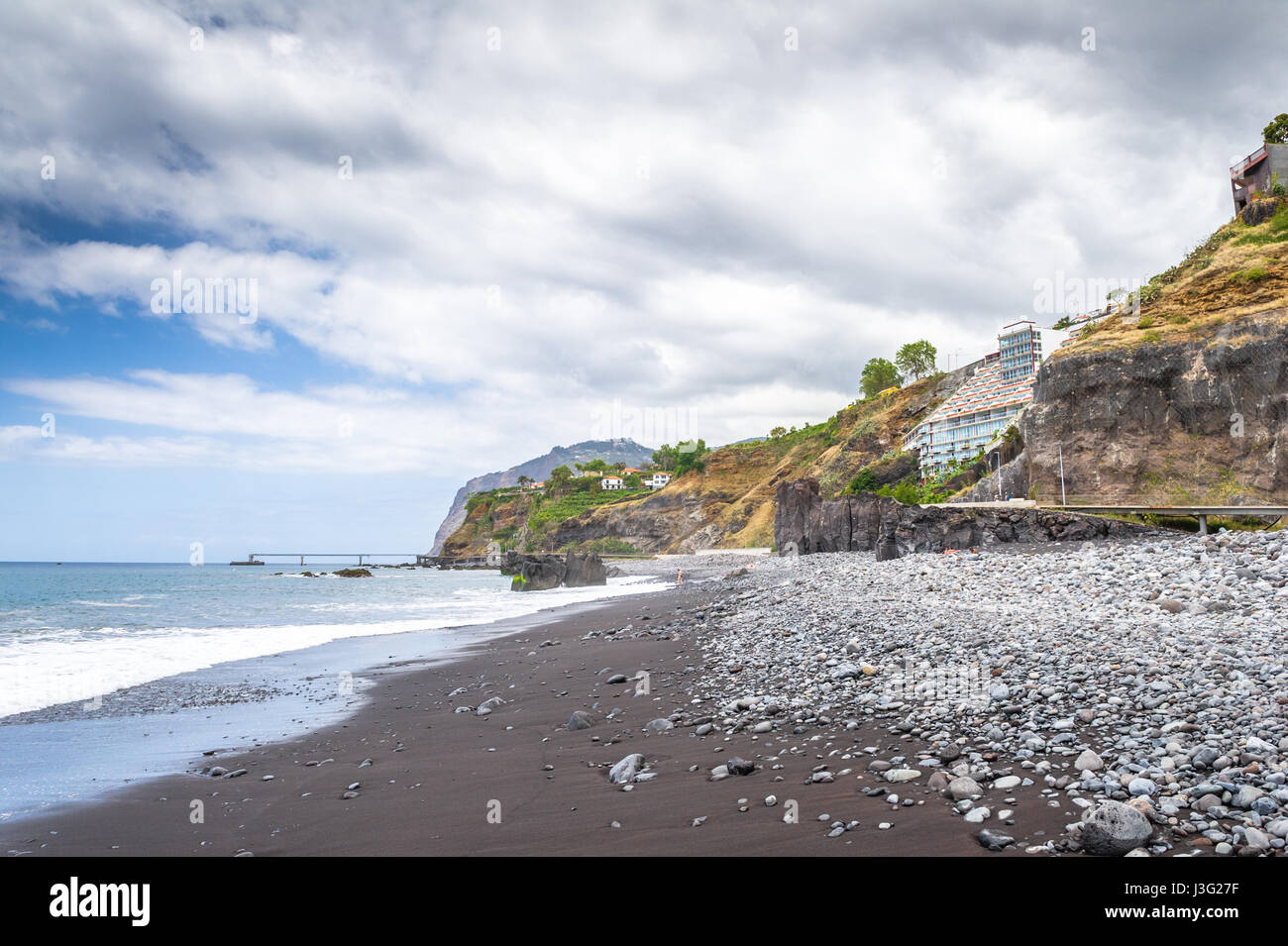 Rocky and dark sandy beach at Funchal on the south coast of Madeira ...