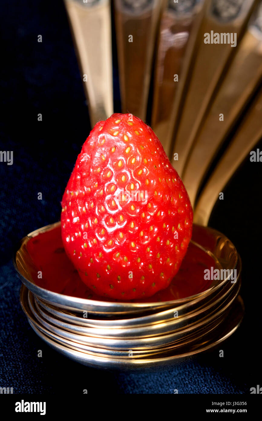 Gold Thai spoons and a strawberry Stock Photo - Alamy