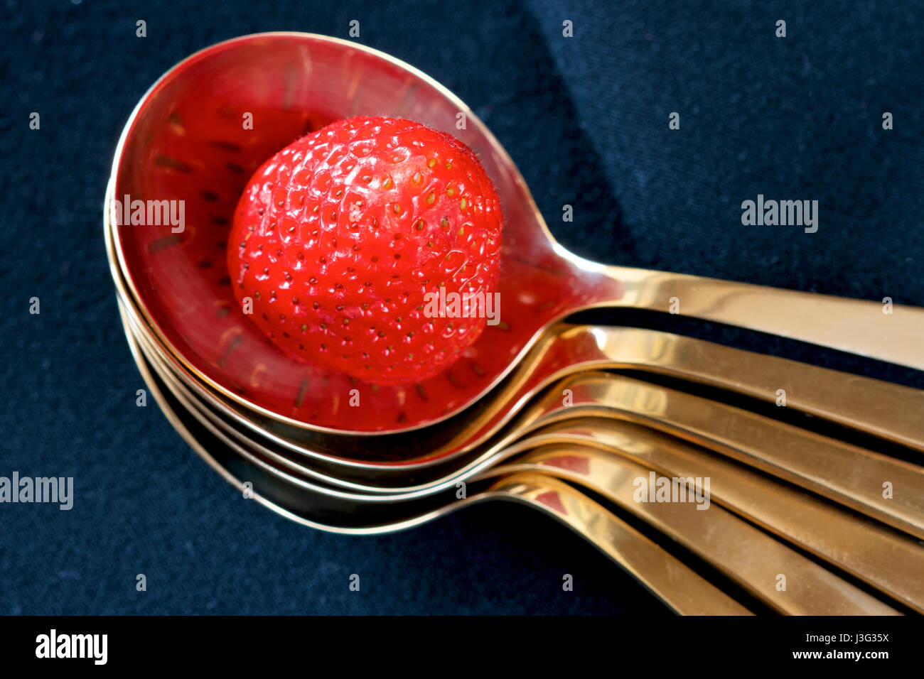 Gold Thai spoons and a strawberry Stock Photo - Alamy