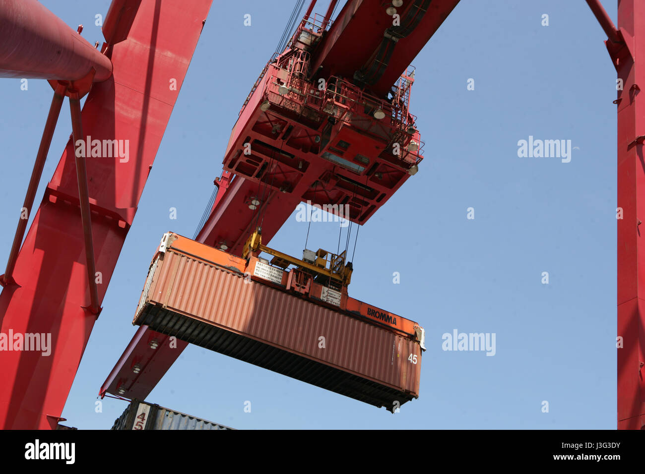 A container being lifted on to a ship by a large crane Stock Photo - Alamy