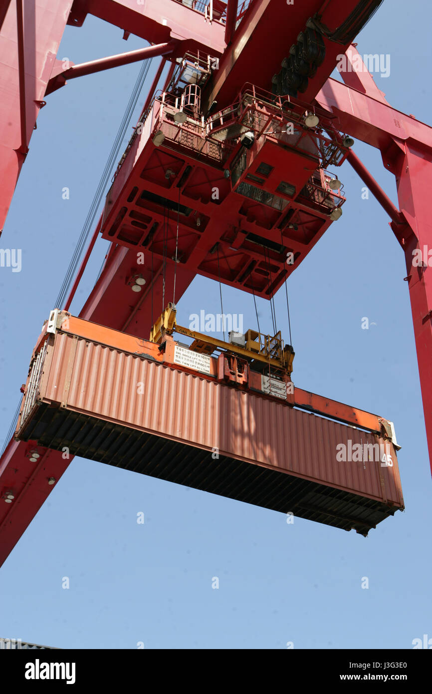 A container being lifted on to a ship by a large crane Stock Photo - Alamy
