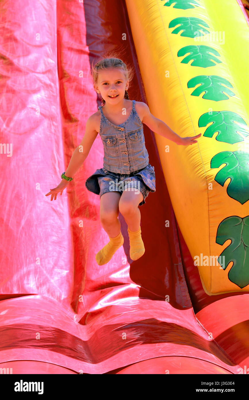 Girl jumping on inflatable attractions in park outdoor Stock Photo - Alamy