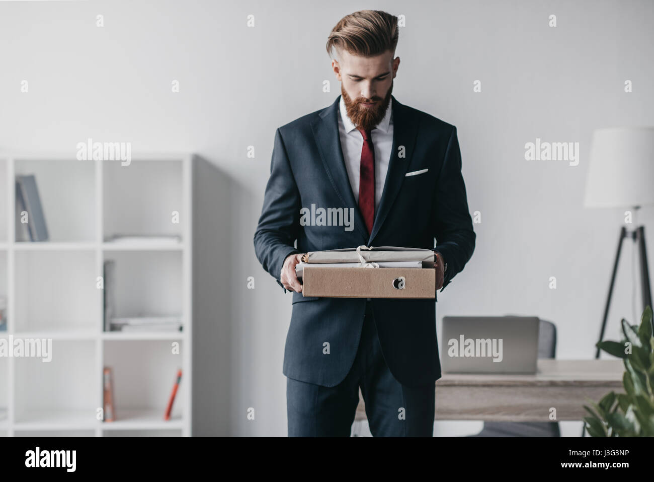 young businessman in suit holding documents and folders in office Stock ...