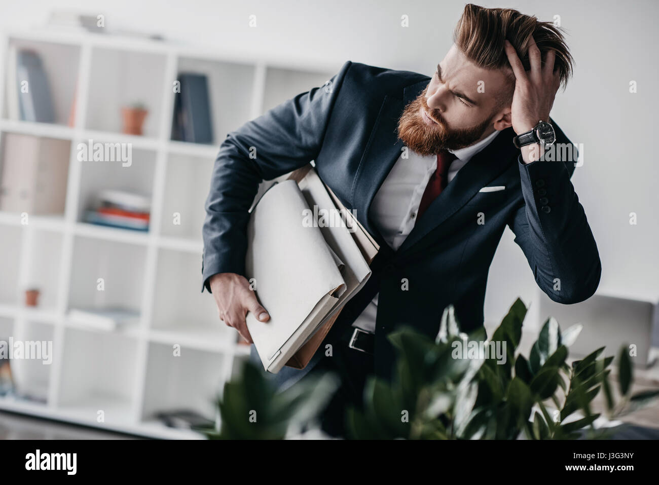 young businessman in suit holding documents and folders in office Stock ...