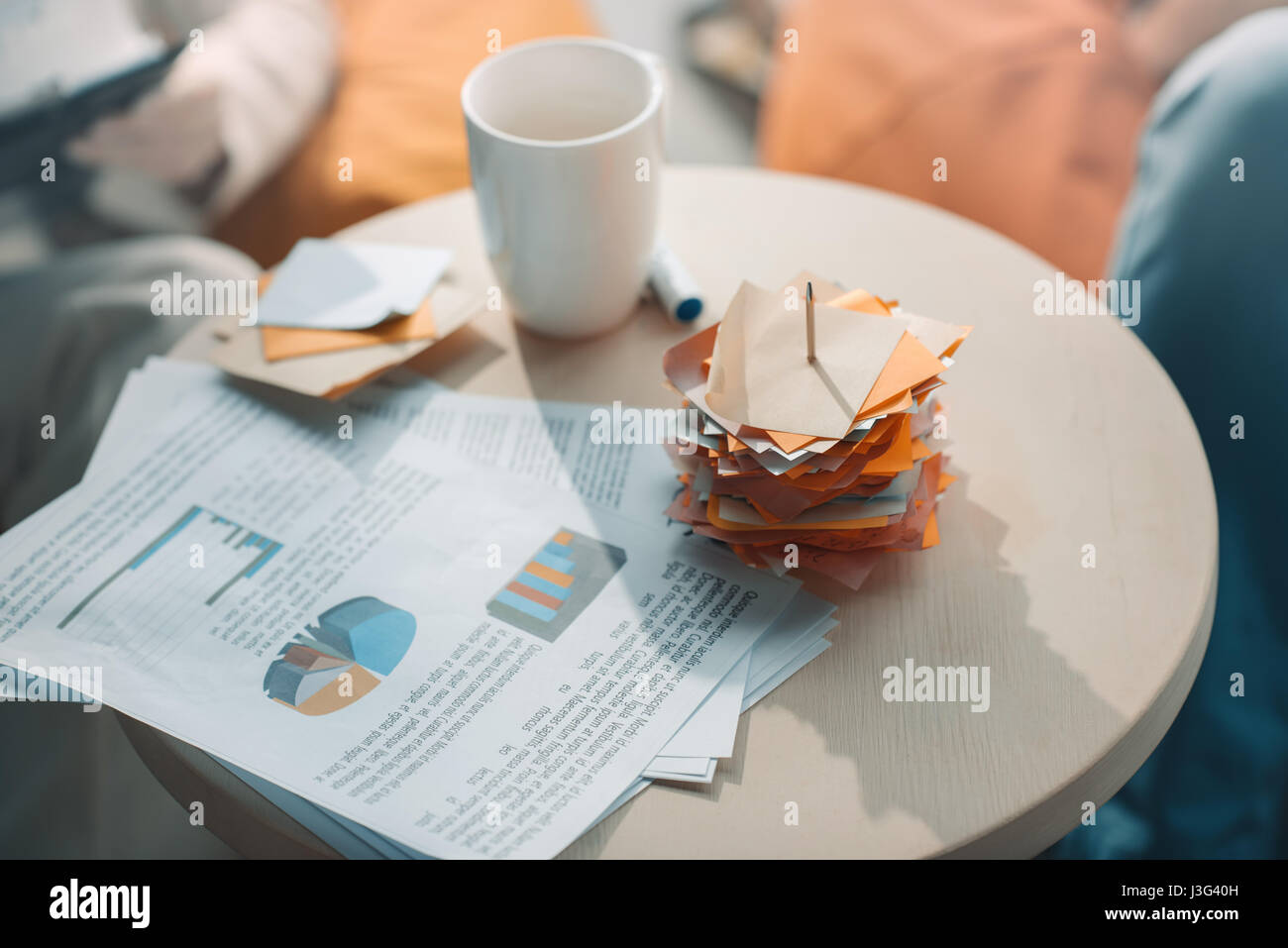 Close-up view of business charts and notes on round wooden table in ...