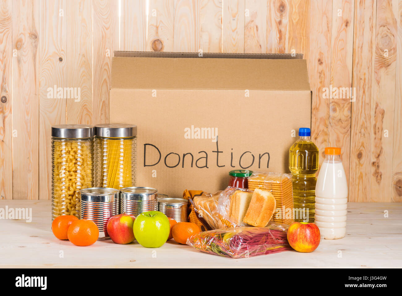 different food with cardboard box and donation sign on wooden table ...
