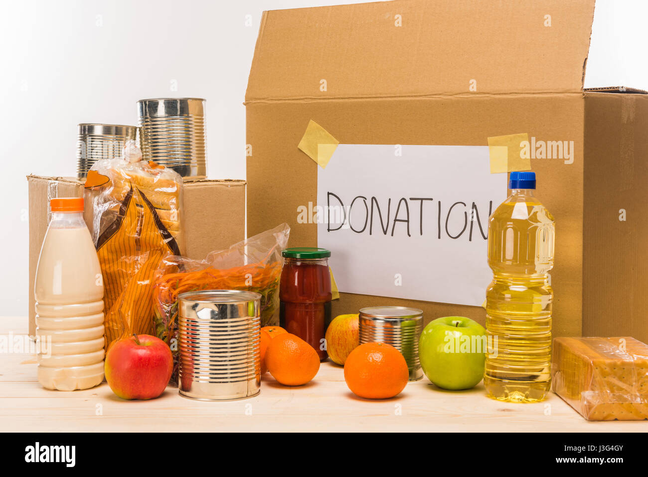 different food with cardboard box and donation sign on wooden table on ...