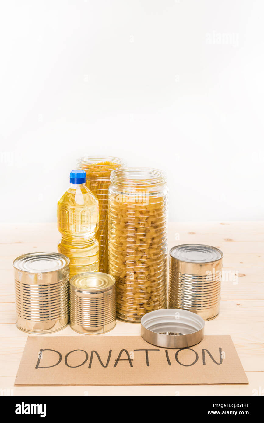different food with cardboard donation sign on wooden table on white ...