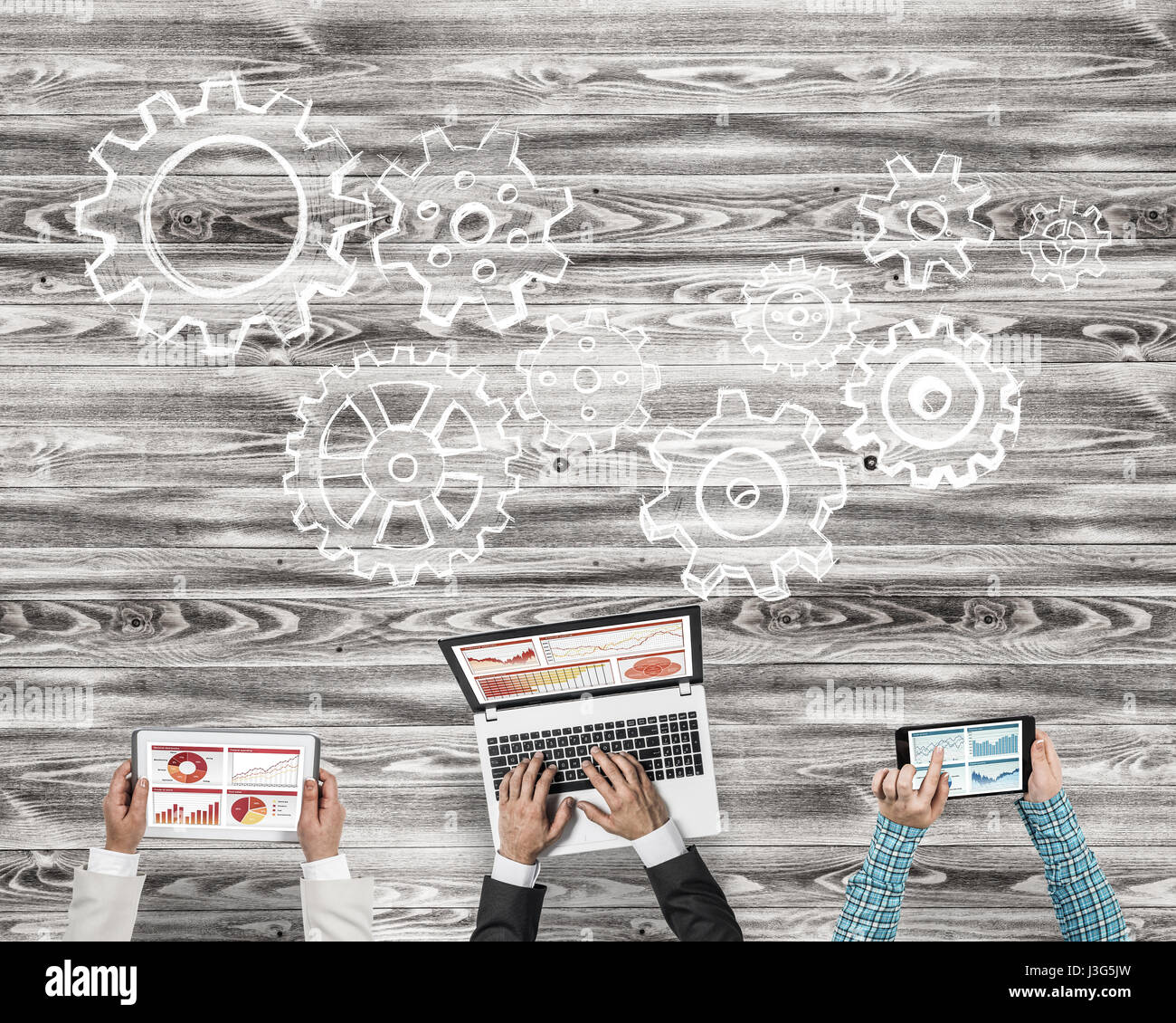Group of three people with devices in hands working together as symbol ...