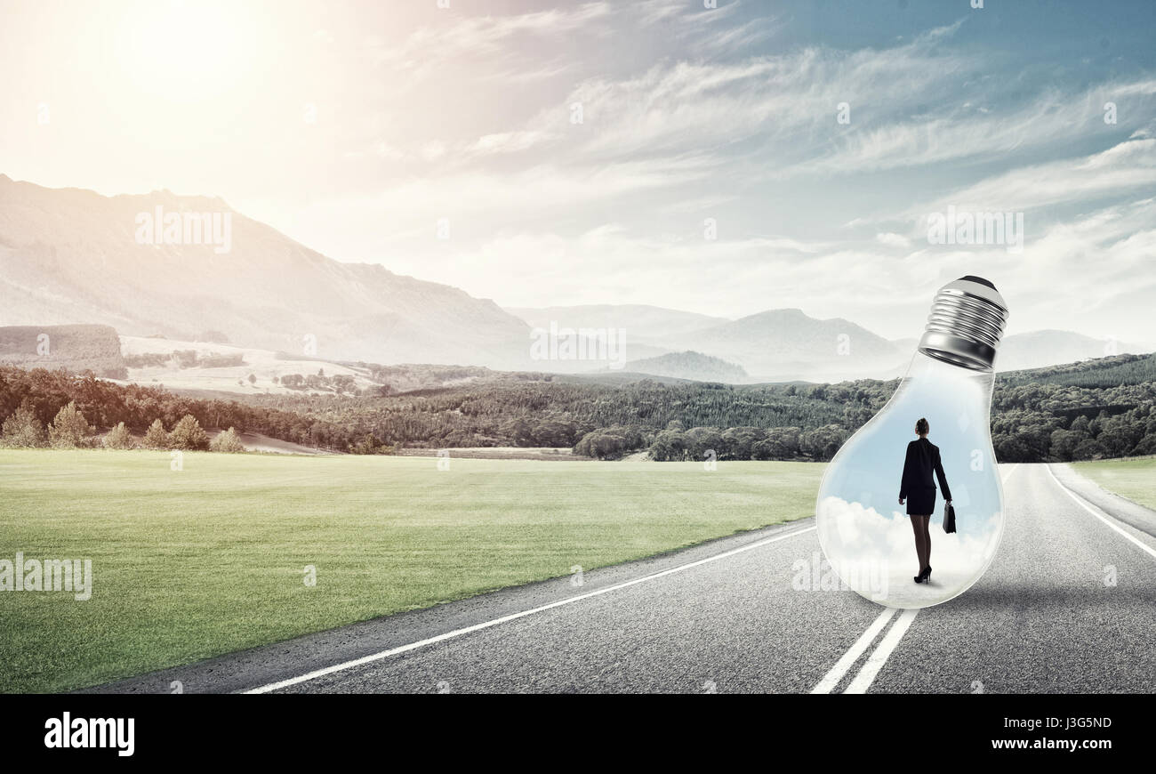 Young businesswoman trapped inside of light bulb on asphalt road Stock ...