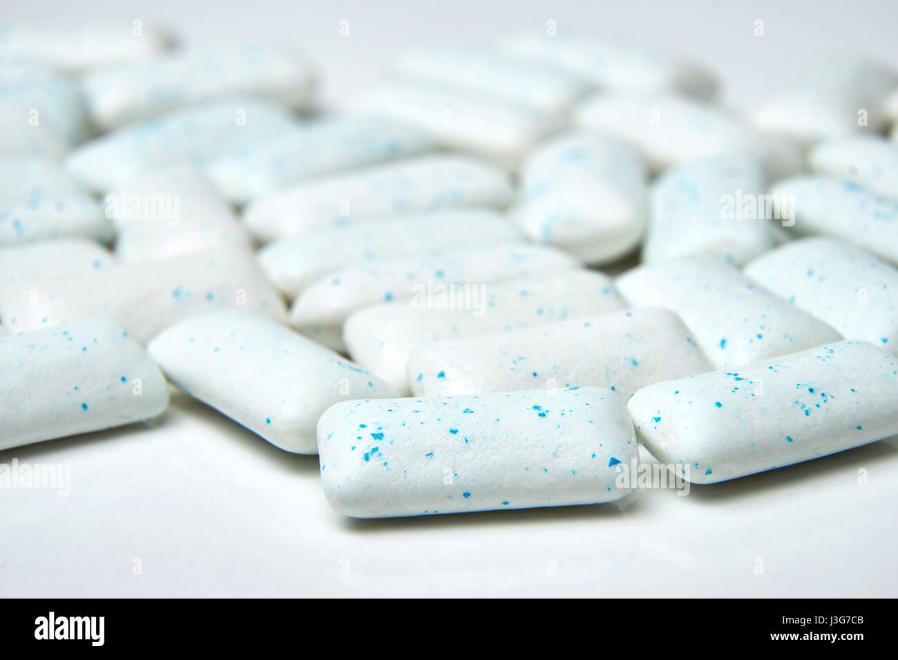 Chewing gum spilled out on white background with low depth of field ...