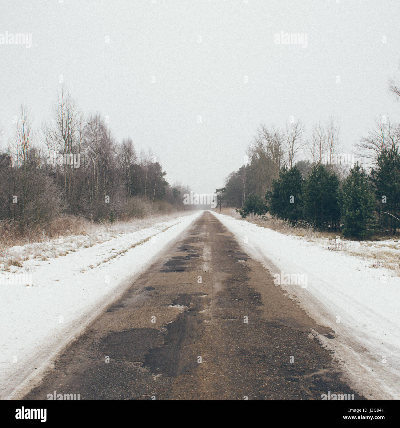 country snowy road in winter, rural area- vintage film grain effect ...