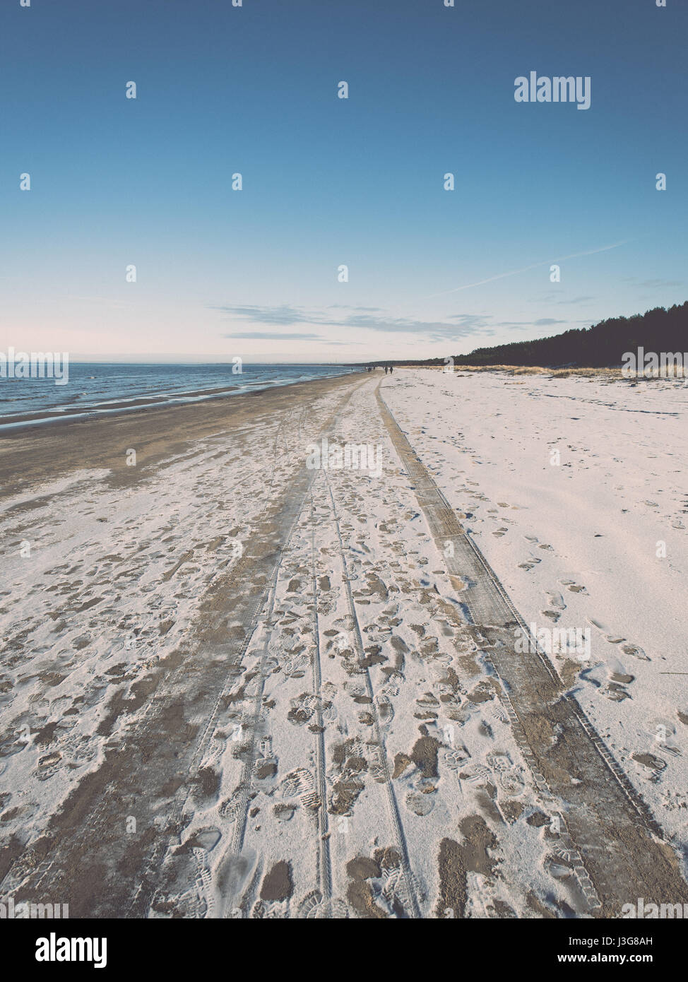 frozen sea beach with blue sky and snow covered tracks - retro vintage ...