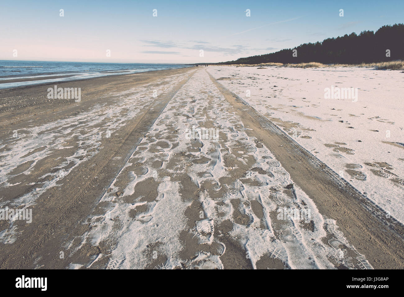 frozen sea beach with blue sky and snow covered tracks - retro vintage ...