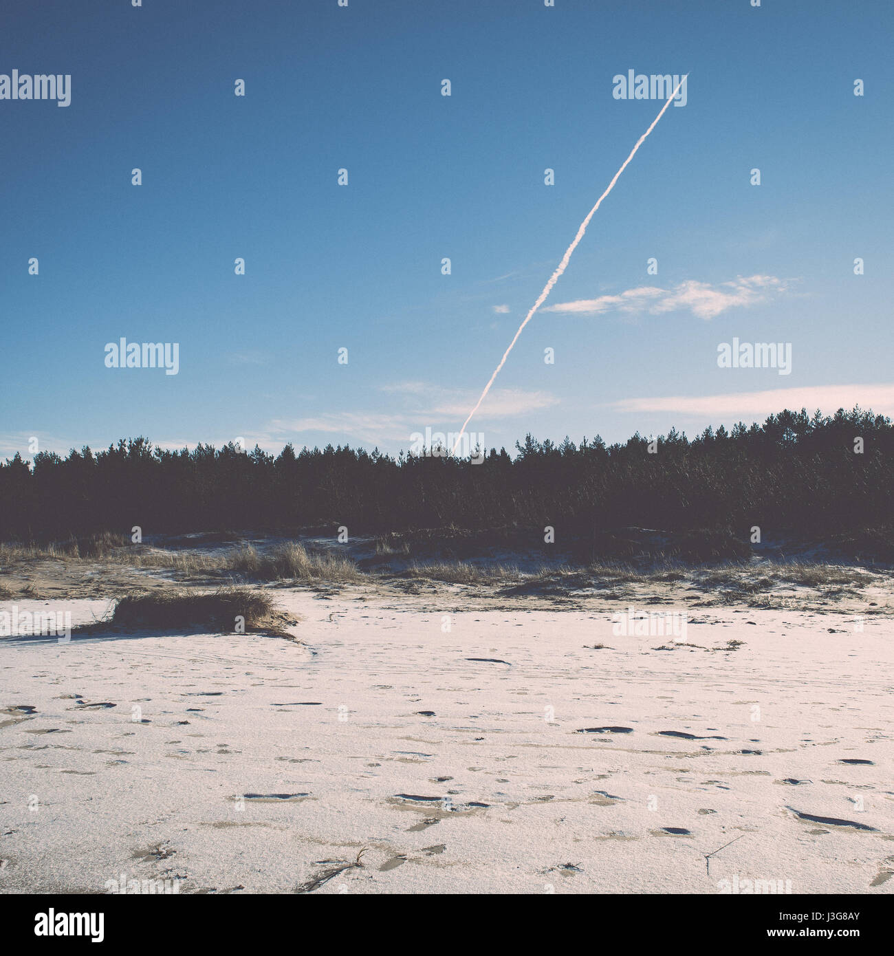 frozen sea beach with blue sky and snow covered tracks - retro vintage ...
