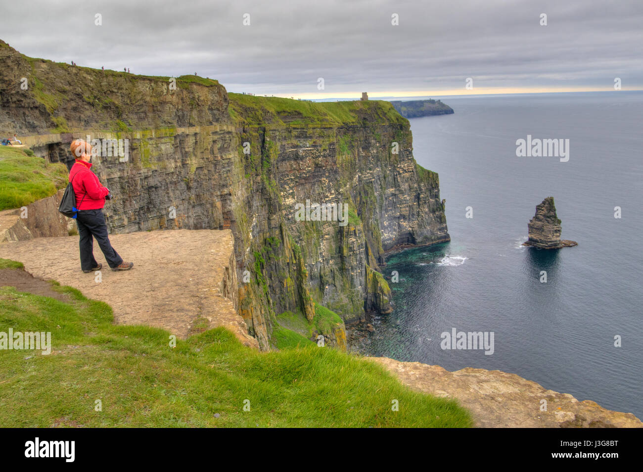 Tourist looking over the Cliffs of Mohr in Ireland Stock Photo - Alamy