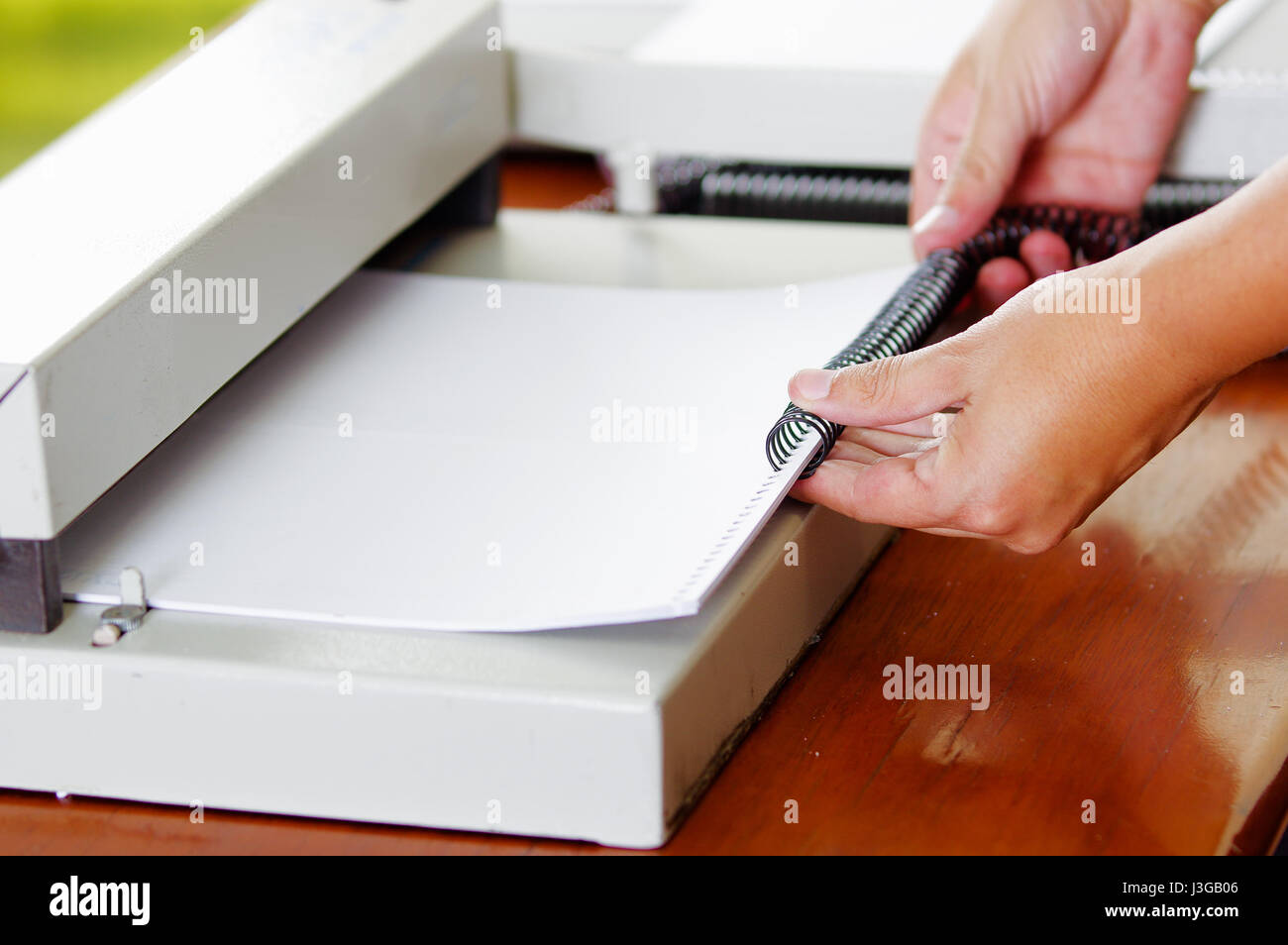 Hard working man using a white useful Binding machine Stock Photo - Alamy