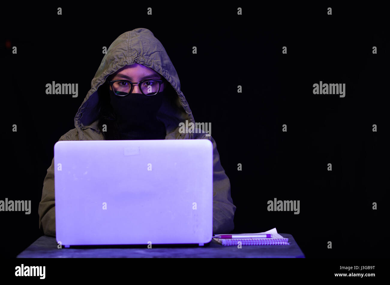 Portrait of hacker with laptop on dark background Stock Photo - Alamy