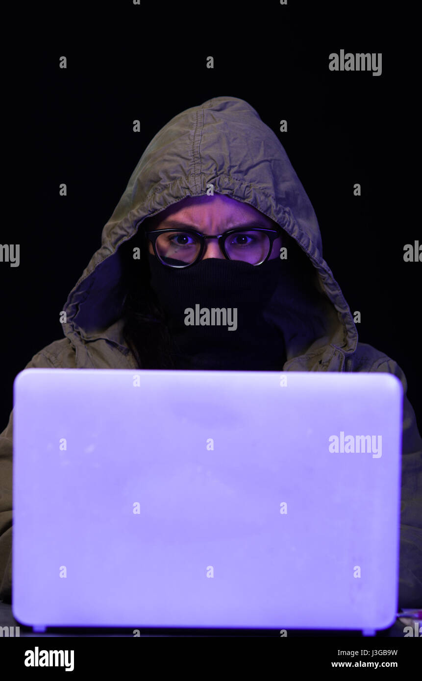 Portrait of hacker with laptop on dark background Stock Photo - Alamy