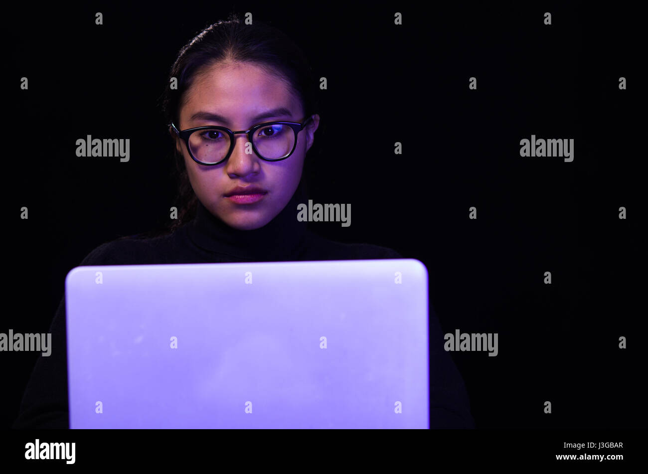 Portrait of hacker with laptop on dark background Stock Photo - Alamy
