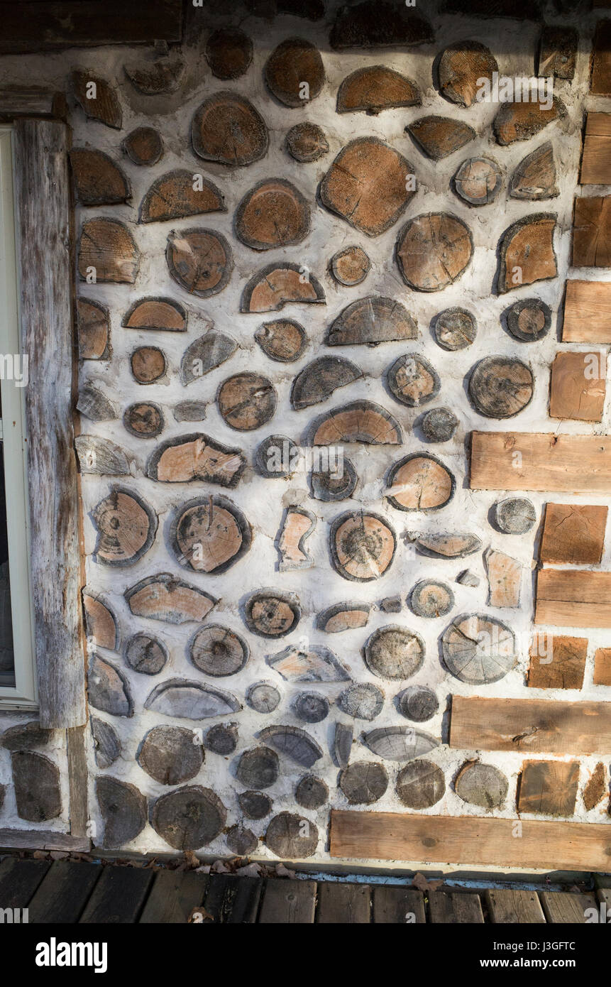 Unusual section of cabin wall made of cement, logs and 4x4 wood. Cable ...
