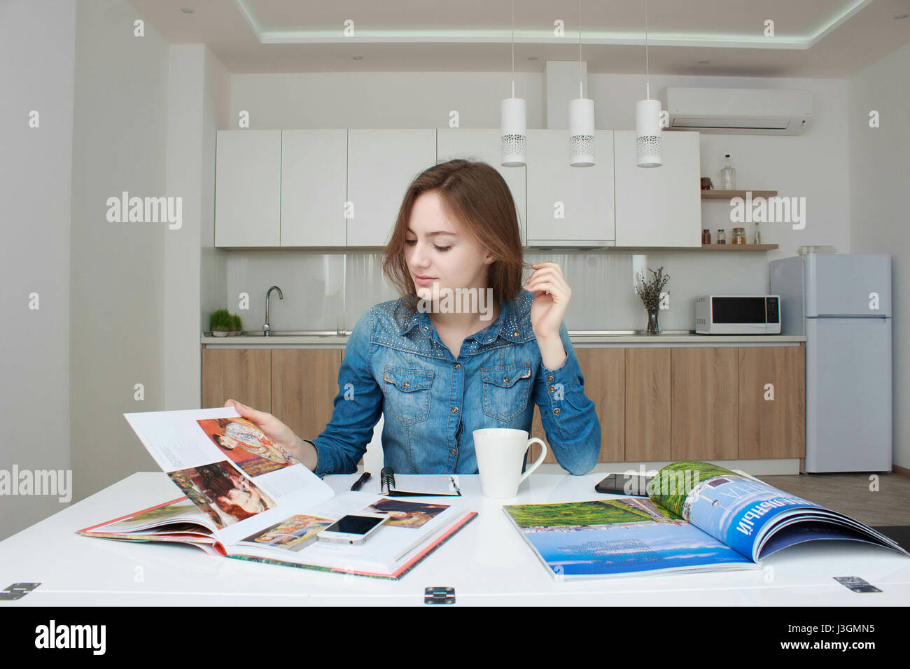 Teenage girl studying reading book at home Stock Photo - Alamy