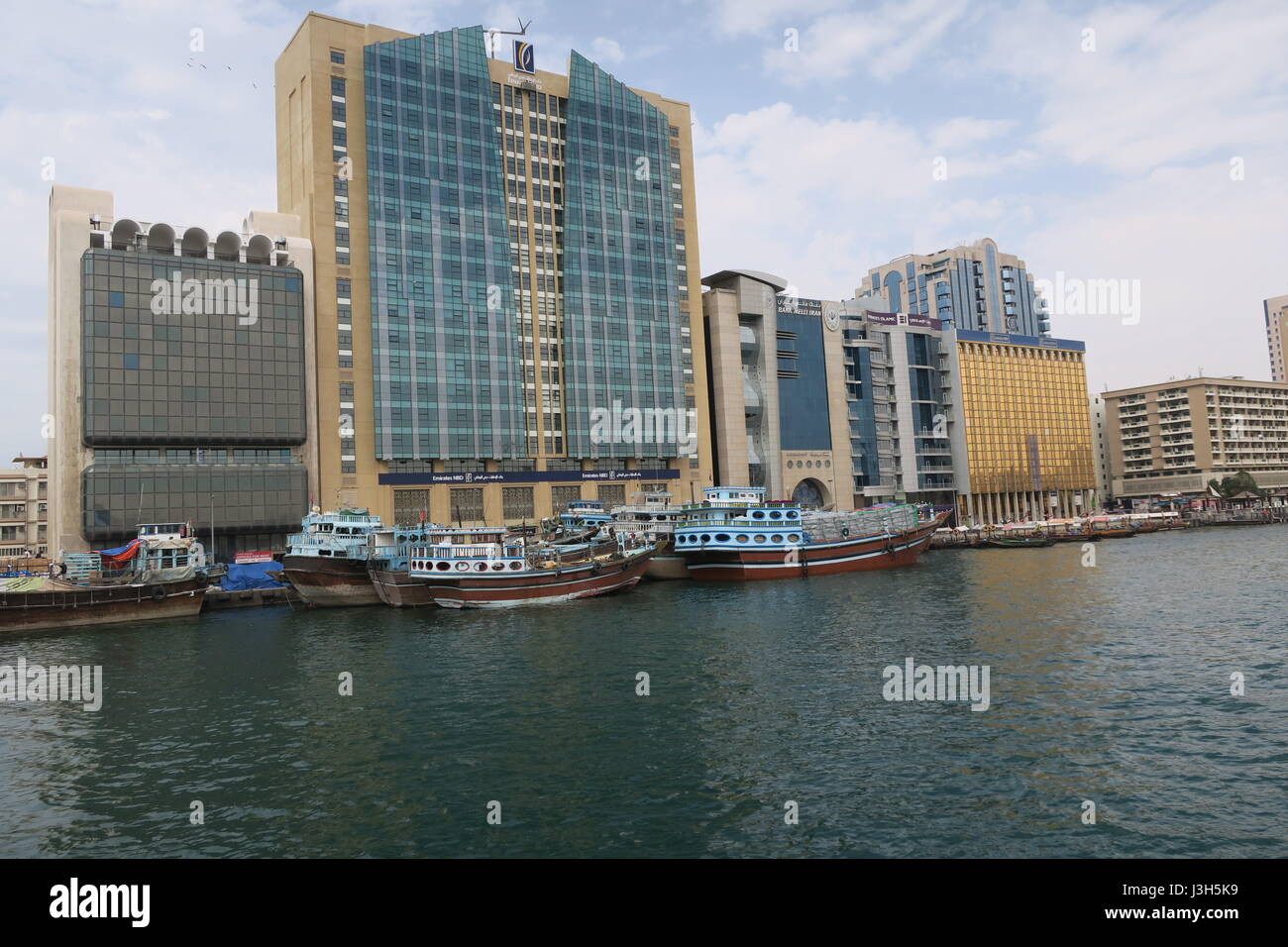 Lots of ships on a sea canal in Dubai. A view at famous skyscrapers ...