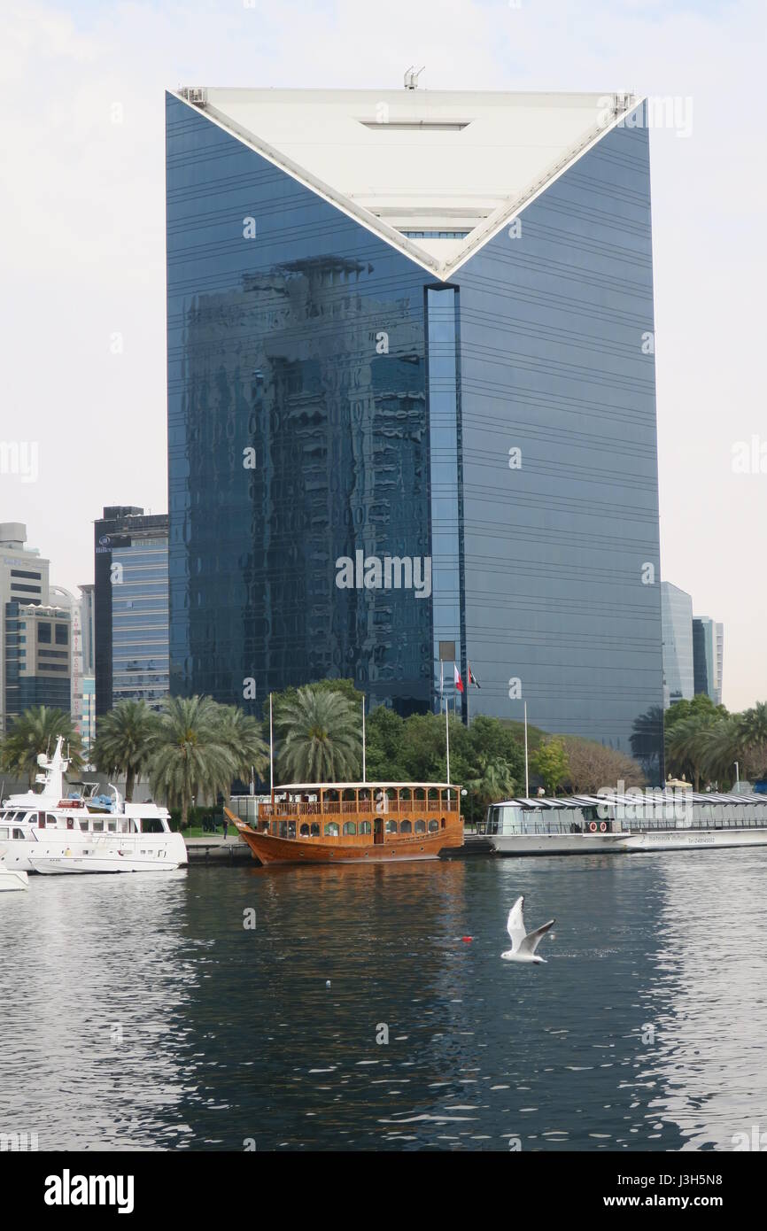 Lots of ships on a sea canal in Dubai. A view at famous skyscrapers ...