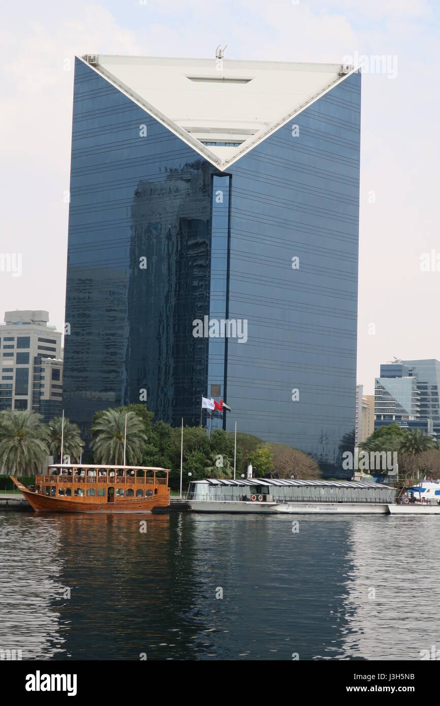 Lots of ships on a sea canal in Dubai. A view at famous skyscrapers ...