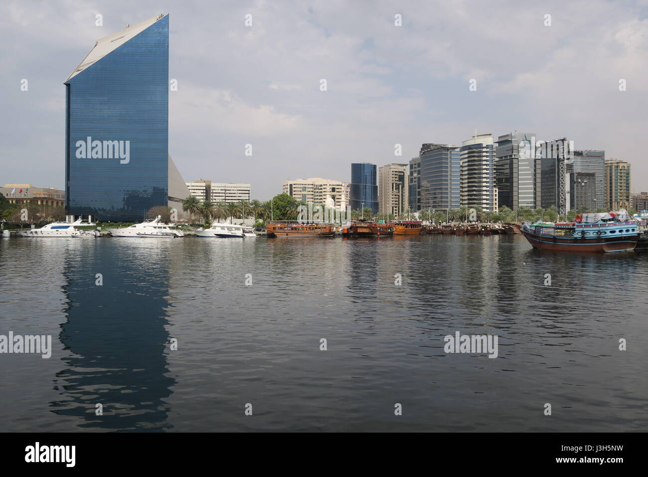 Lots of ships on a sea canal in Dubai. A view at famous skyscrapers ...
