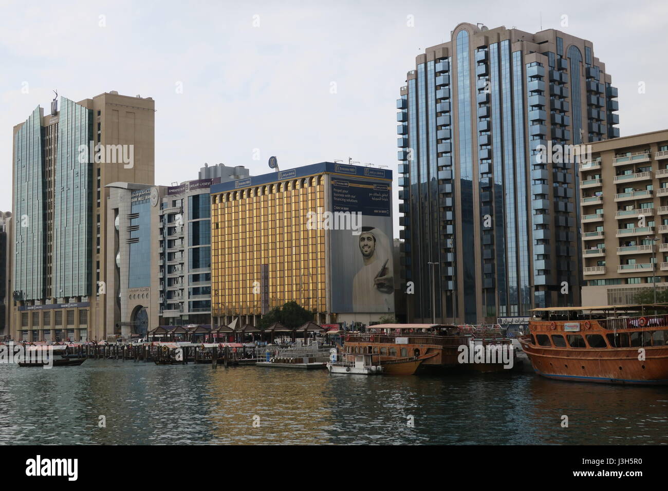 Lots of ships on a sea canal in Dubai. A view at famous skyscrapers ...