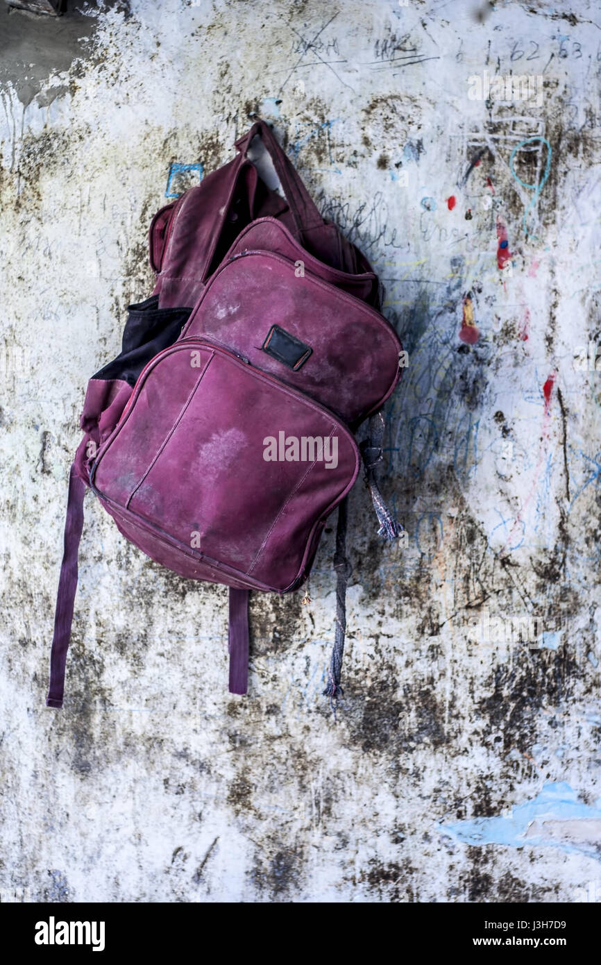 A maroon school bag hanging on a wall Stock Photo - Alamy