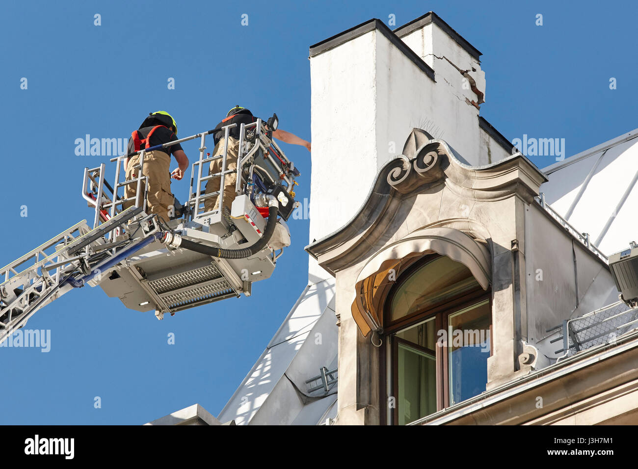 Firemen on a crane fixing a structural building fissure. Working Stock ...