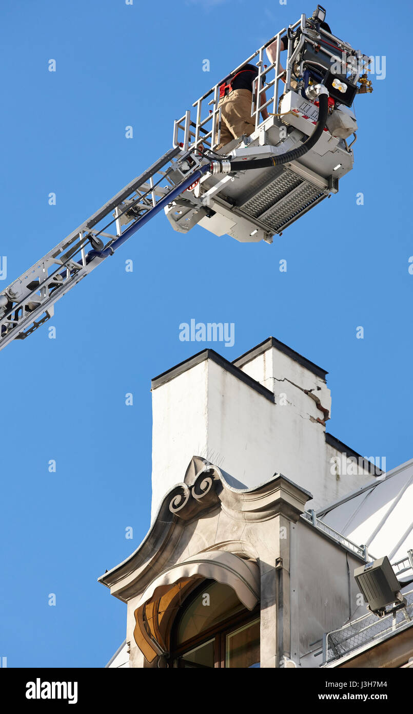 Firemen on a crane fixing a structural building fissure. Working Stock ...