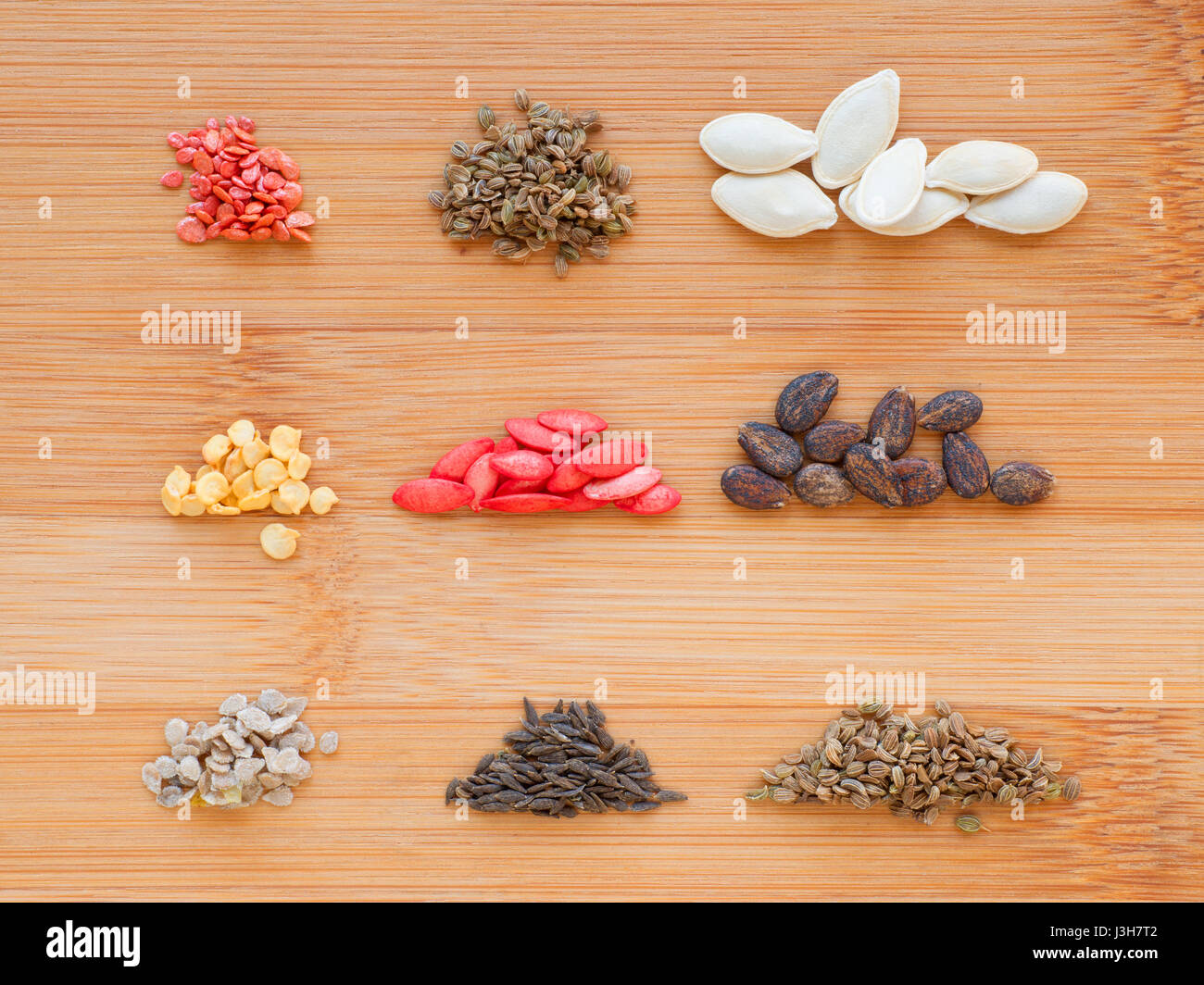 Different seeds set on wooden board background. Eight small separated ...