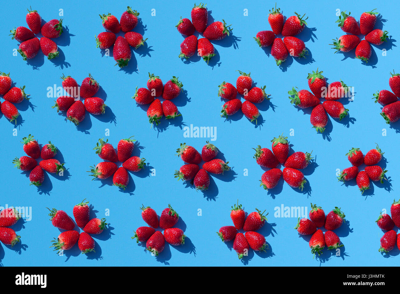 Strawberries on blue background Stock Photo - Alamy