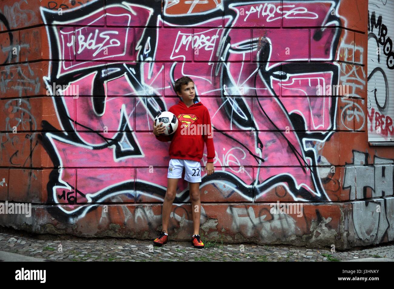 Stock Photo - Berlin, Germany. Young boy plays football on a street ...