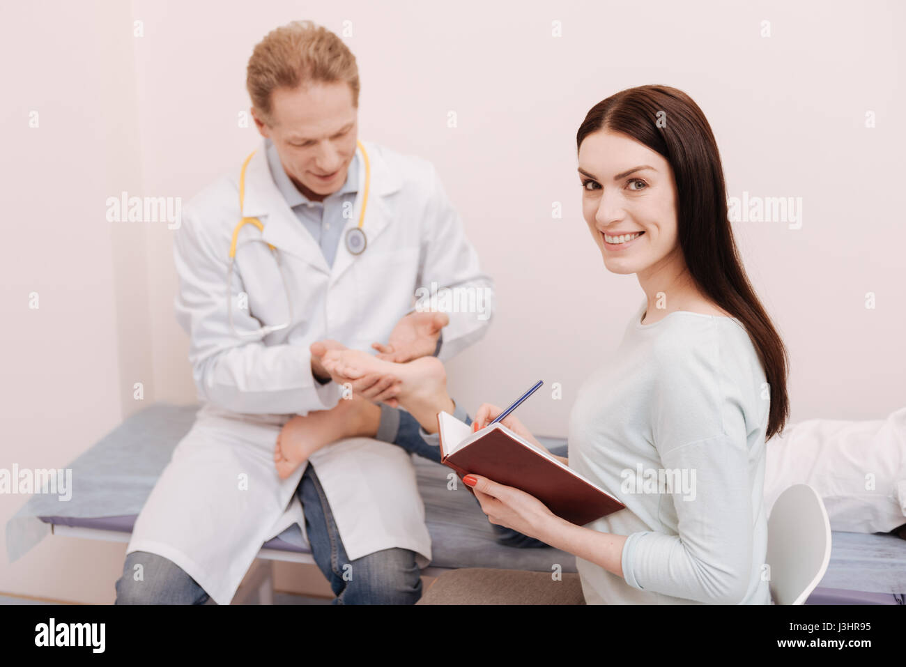 Noting the tips. Enthusiastic caring clever lady using a notebook for ...