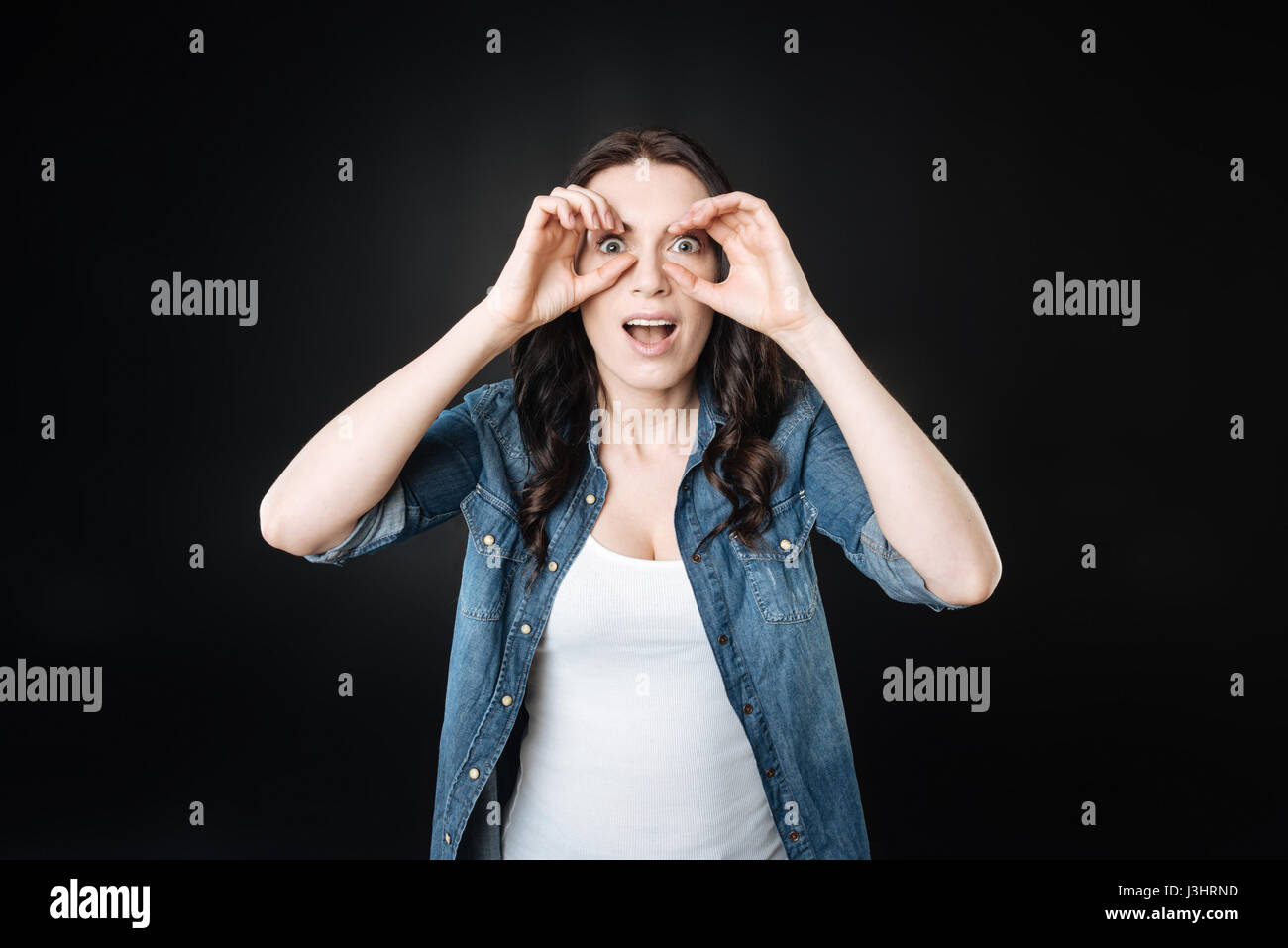 Look at this. Beautiful brunette opening her eyes wide rising hands to ...