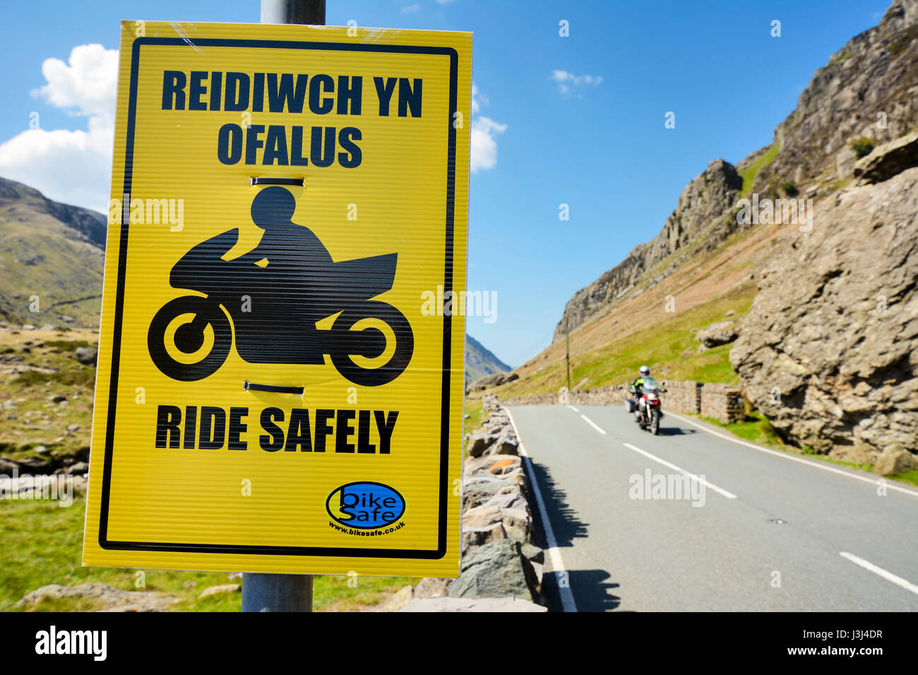 Bright yellow notice attached to clearway sign advising motorcyclists ...
