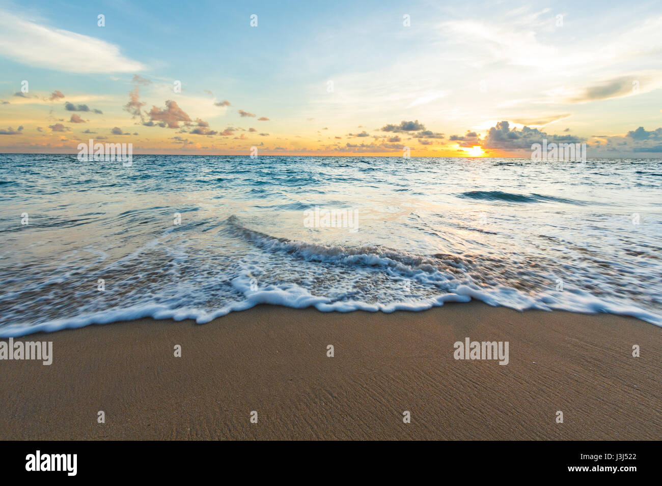 Small surf on the beach in South of Thailand at dusk Stock Photo - Alamy