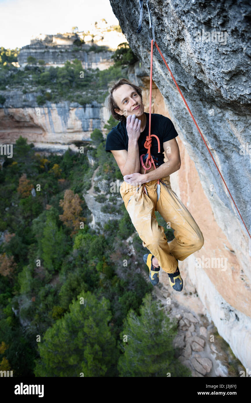 Outdoor sport activity. Rock climber ascending a challenging cliff ...