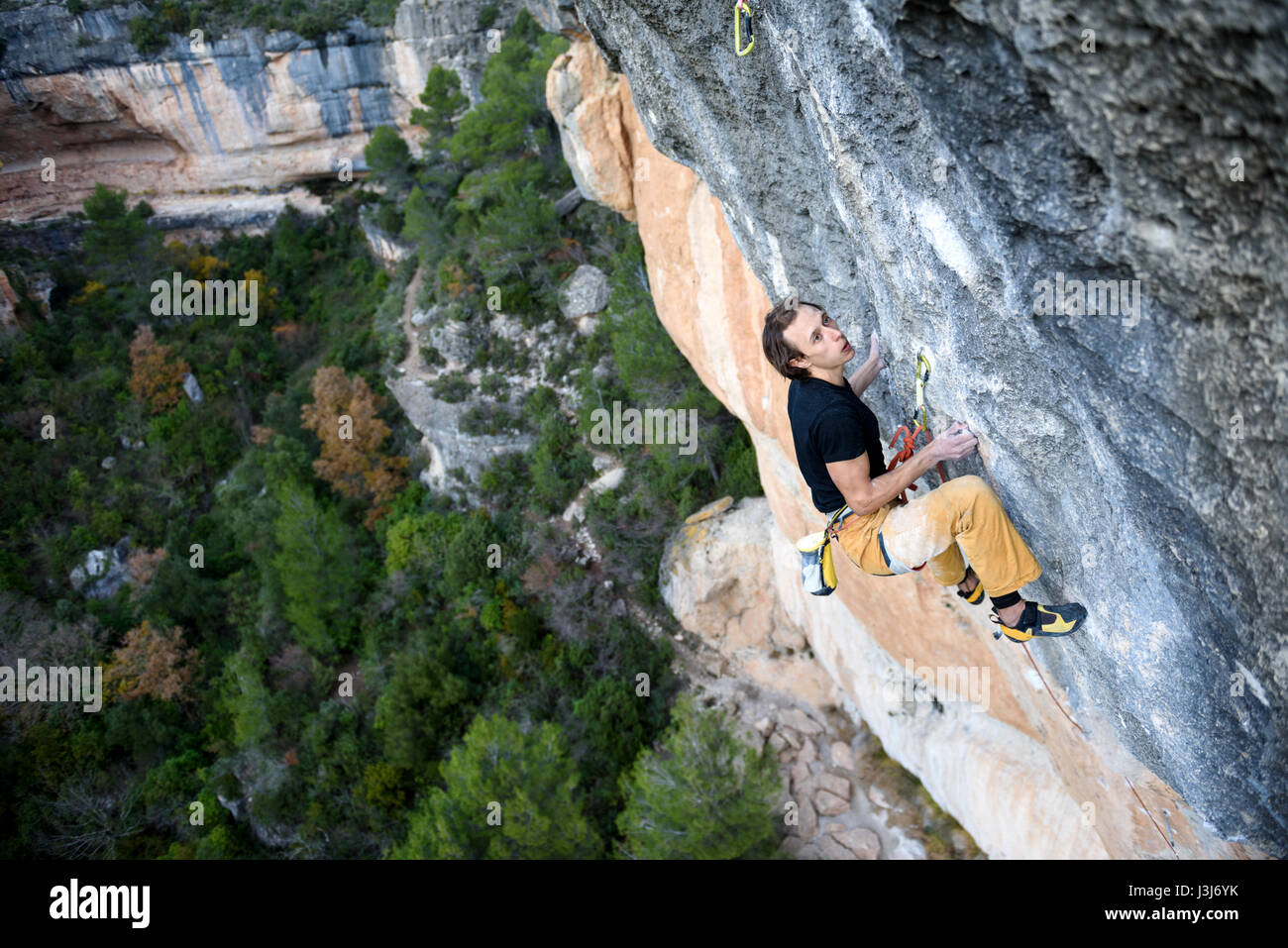 Outdoor sport activity. Rock climber ascending a challenging cliff ...